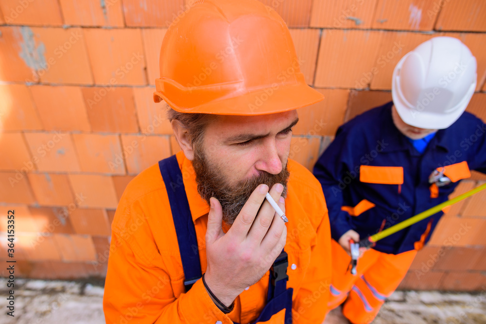 Builder man construction worker smoking cigarette. Foreman in safety ...