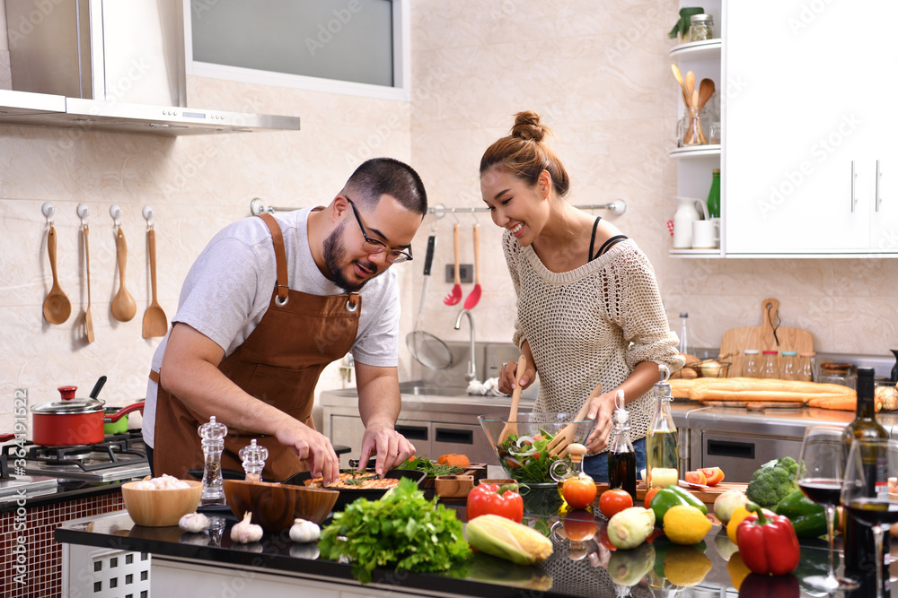 Loving young Asian couple cooking in kitchen making healthy food ...