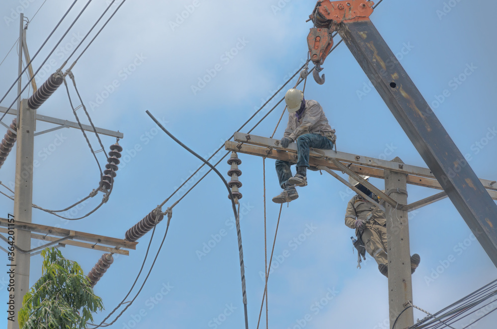 Technician men fixing or repairing broken power line on electric pole ...