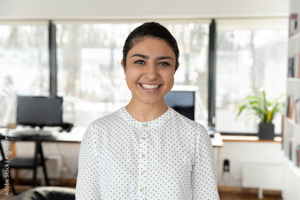 Headshot portrait of smiling indian female employee look at camera pose ...