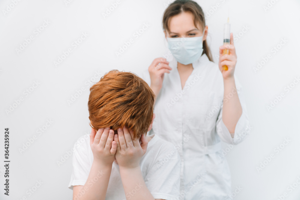 Little boy is afraid of the doctor with a syringe. Baby cries afraid ...