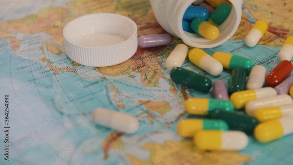 The pill container and capsules are placed on the map surface. Stock ...