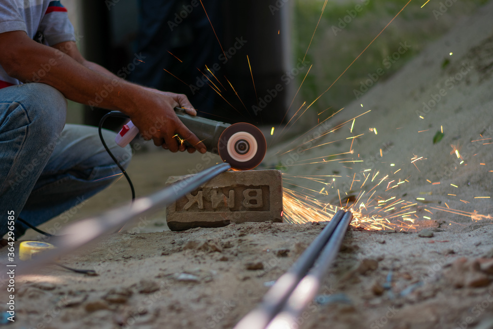 Construction worker. Cutting metal rod with grinder machine. Stock ...