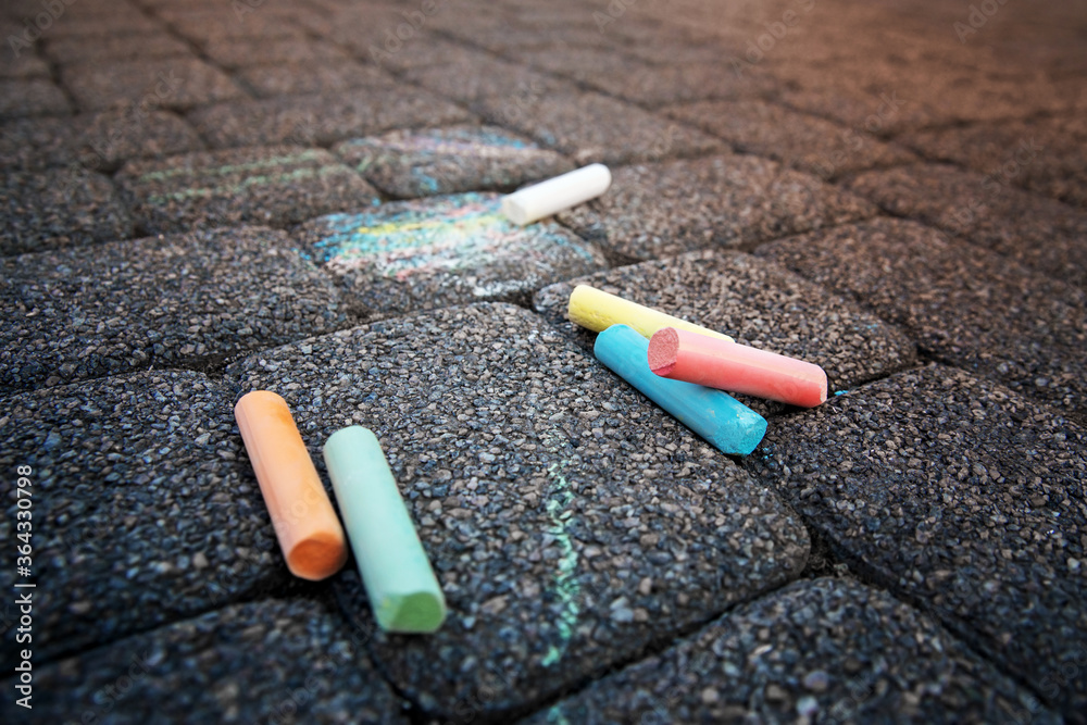 Colored chalk on playground with drawings on street.children drawing on ...