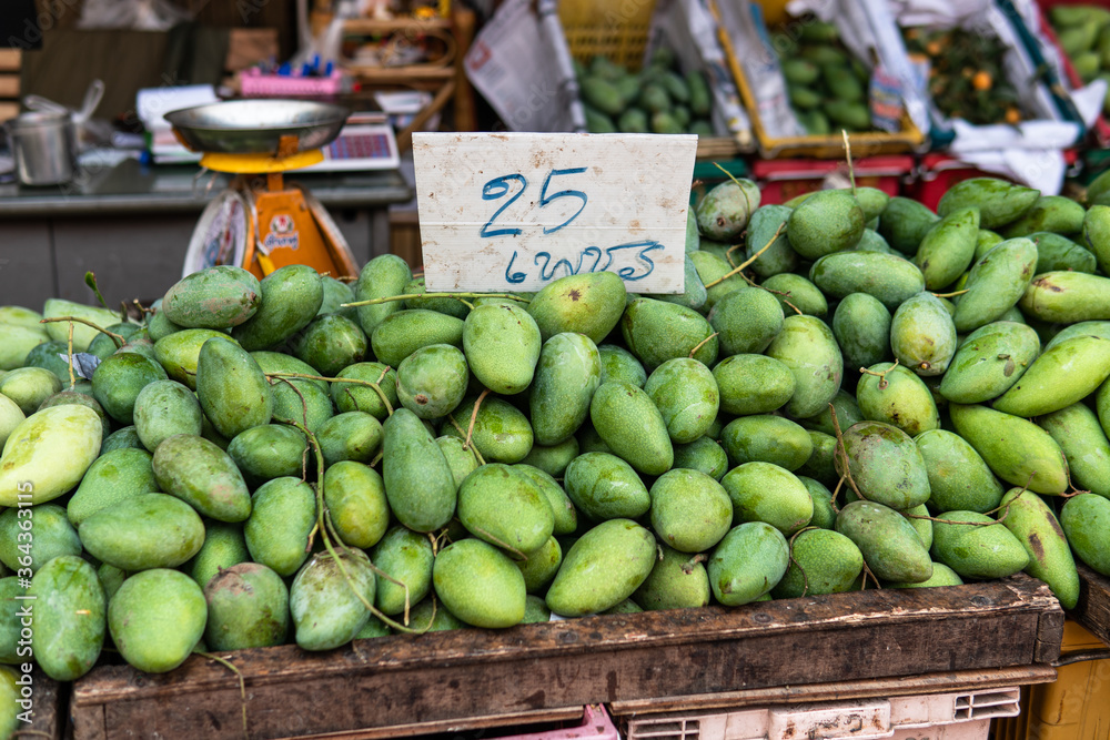 green mangoes lying on a market counter. Exotic fruits of Asia Stock ...