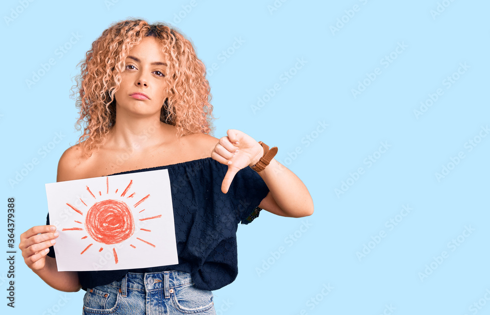 Young blonde woman with curly hair holding sun draw with angry face ...