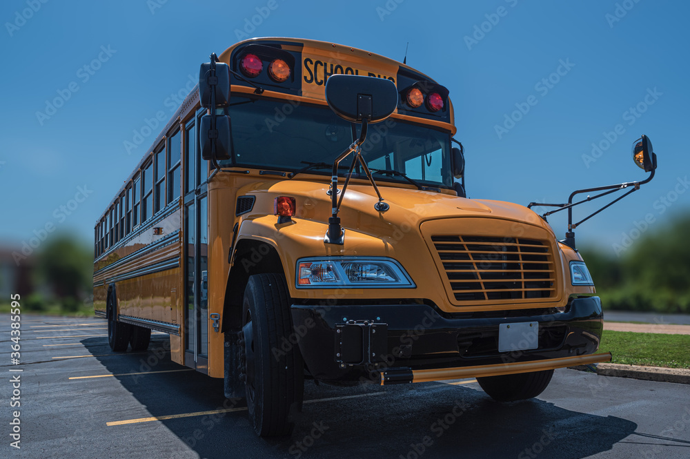 Low front right angle view of yellow American public school bus showing ...