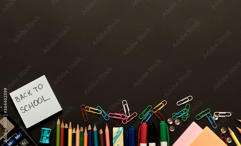 Back to school. Various school supplies on a dark background. The ...
