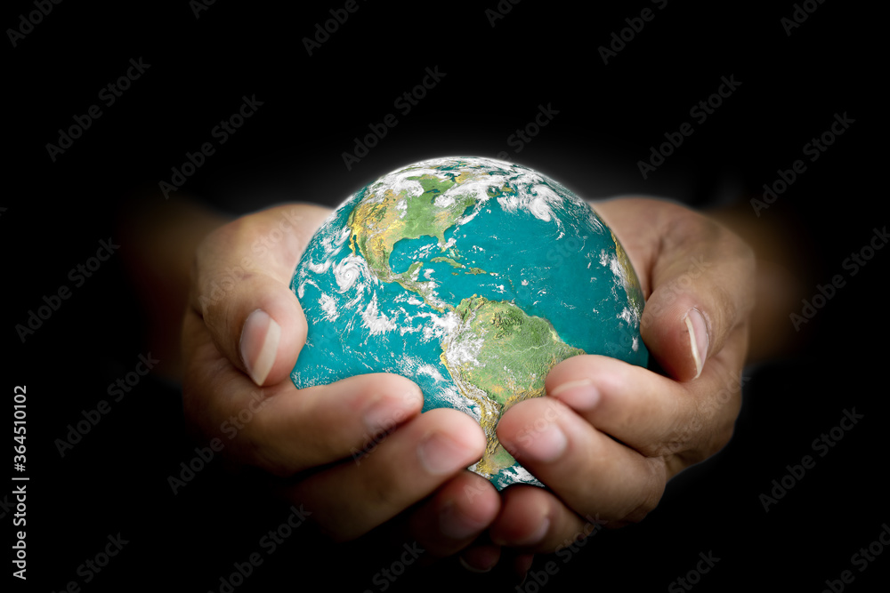 Environment concept. Earth with light in human hand on black background ...