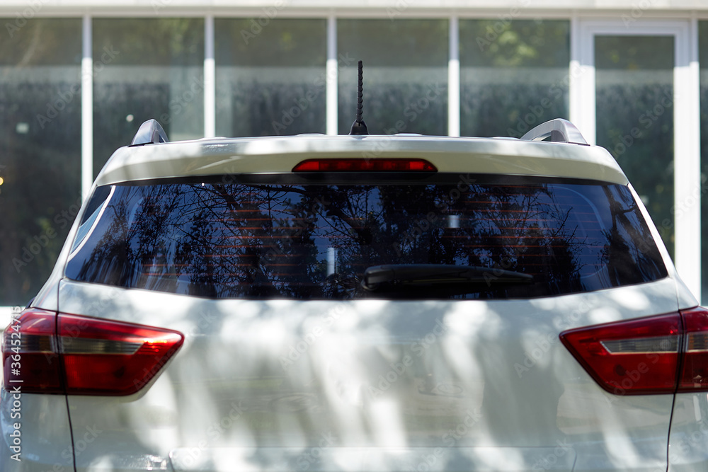 Back window of white car parked on the street in summer sunny day, rear ...
