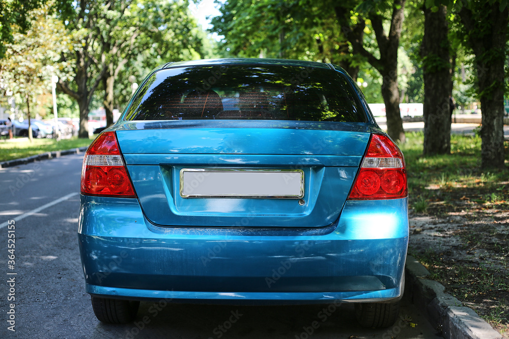 Back window of blue car parked on the street in summer sunny day, rear ...