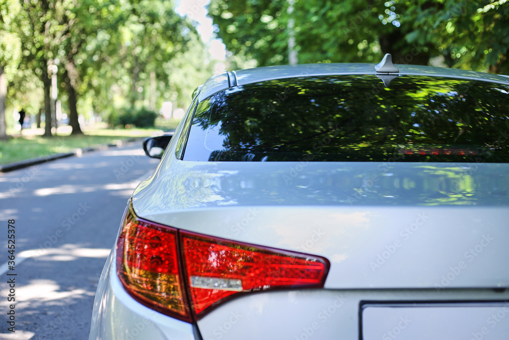 Back window of grey car parked on the street in summer sunny day, rear ...
