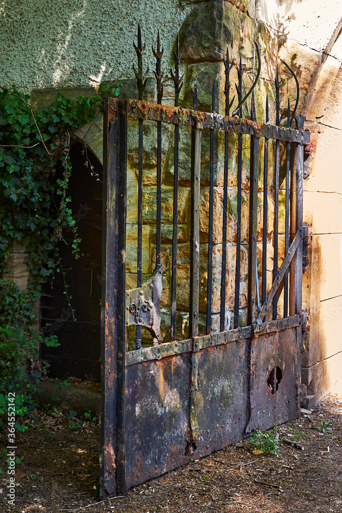Access to a small old castle. In the center you can see a rusty wrought ...