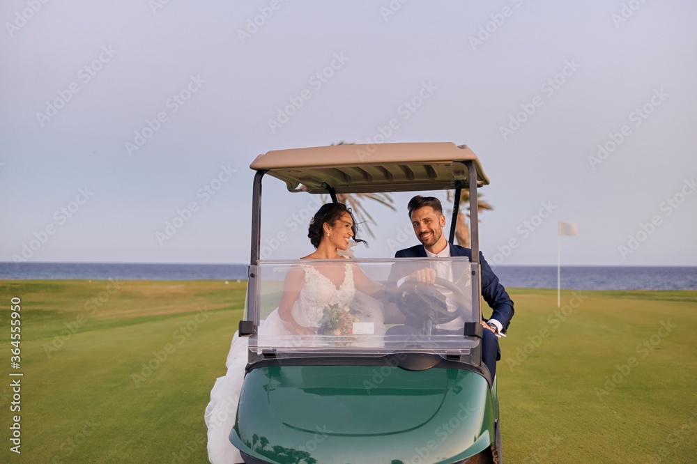 Smiling bride with bouquet of flowers and handsome groom in classy suit ...