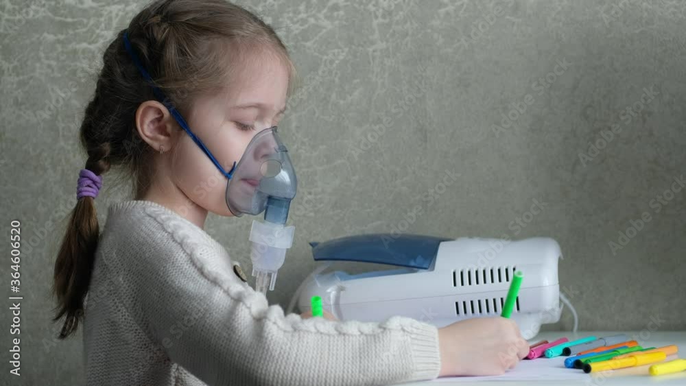 Little girl makes an inhalation vapor and draws a drawing. Child is ...