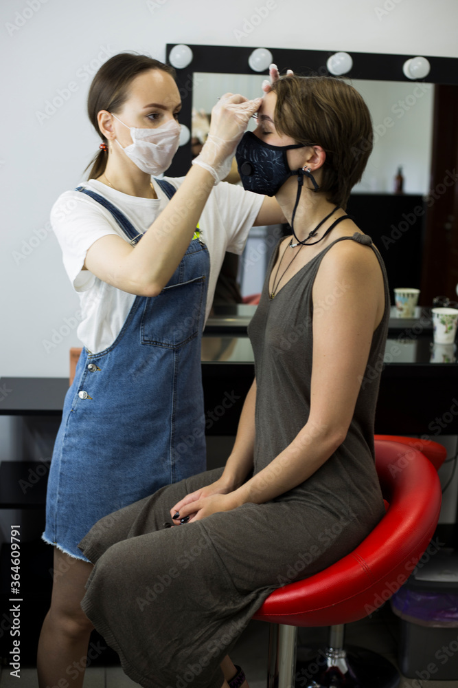 eyebrow master is making beautiful eyebrows to her client in the beauty ...