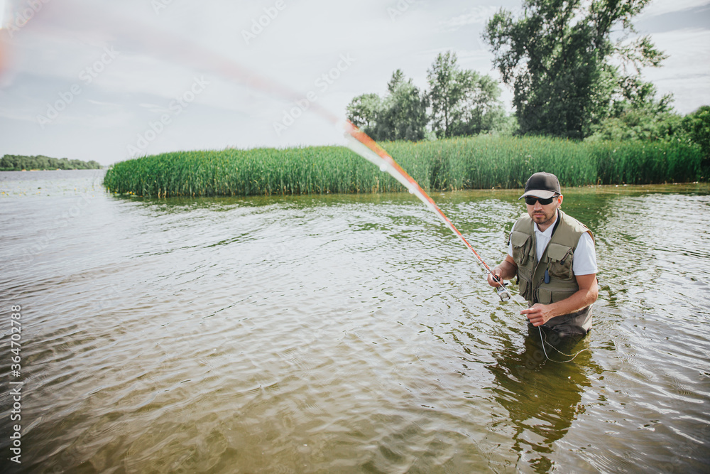 Young fisherman fishing on lake or river. Picture of guy in robe ...