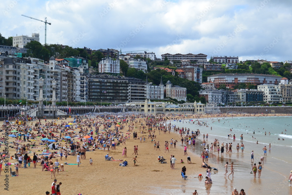 Beach. Playa de la Concha full of bathers enjoying the sunny day and ...