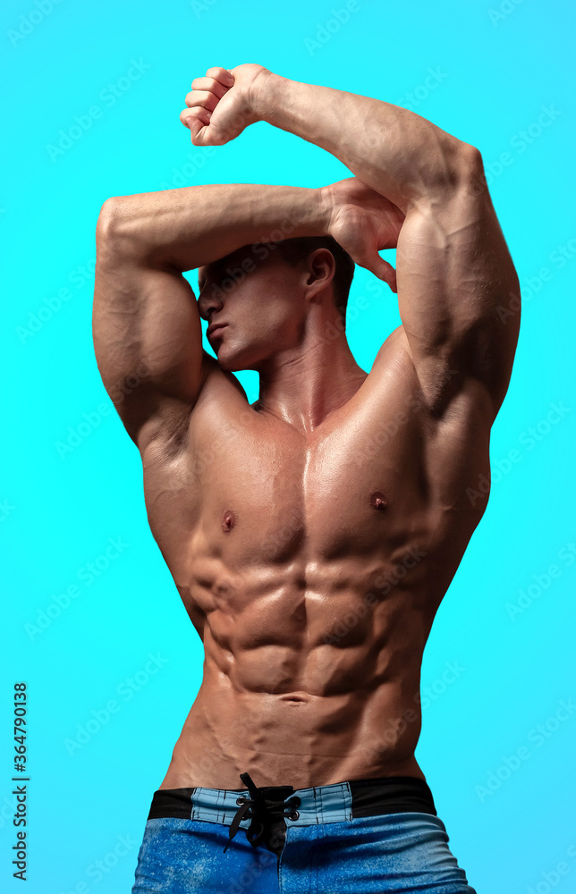 Sexy, muscular man posing on a blue background, isolated. Fitness model ...