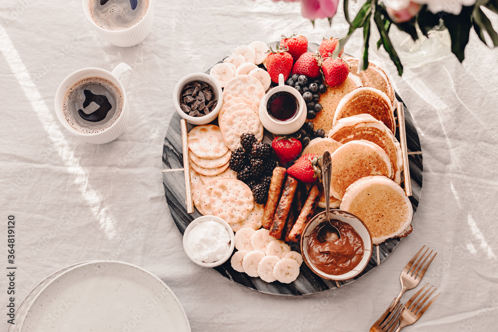 Breakfast platter. Table setting. Pancakes, breakfast sausages, berries ...