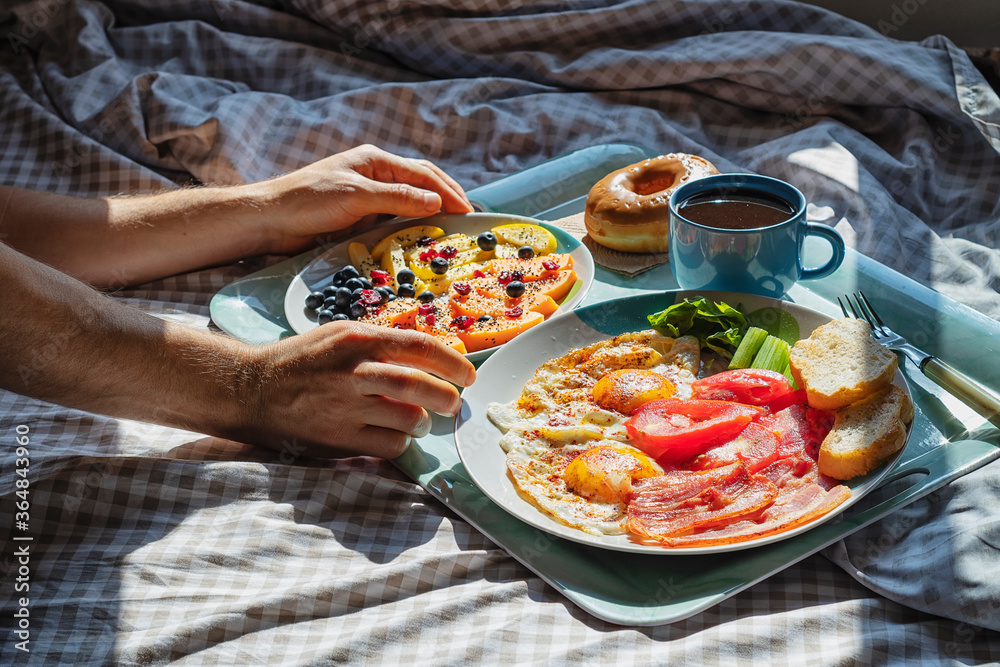 A person is ready to eat a morning breakfast at bed in a trey with ...