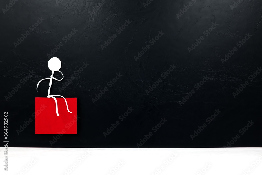Human stick figure sitting alone while thinking in black background ...