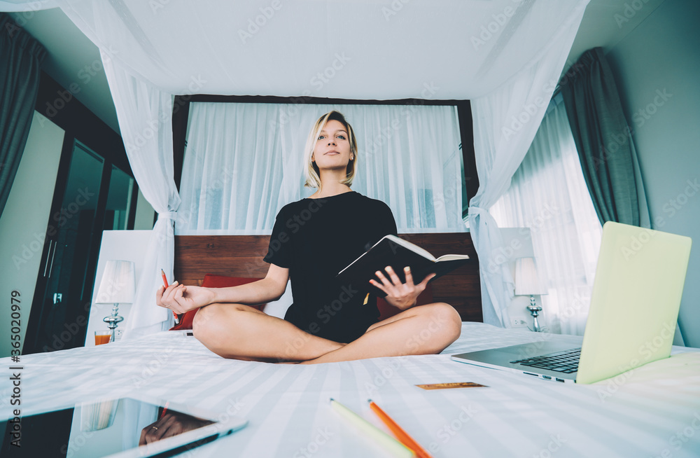 Funny female blogger sitting in lotus pose waiting for inspiration for ...