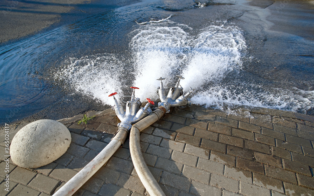 Triple fire hose connection spraying dirty water from central water ...