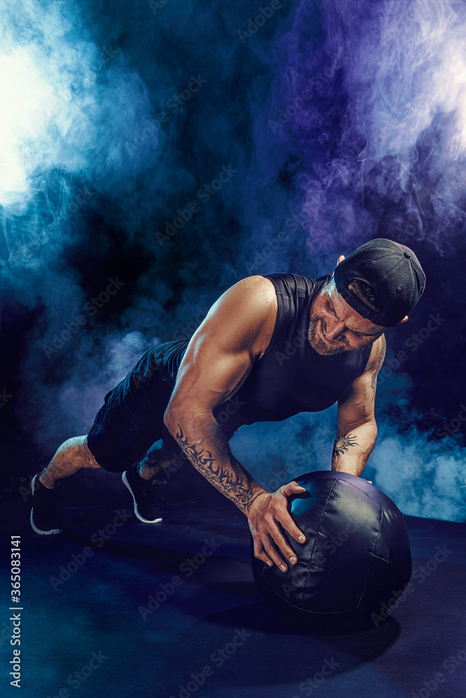 Aggressive bearded muscular sportsman is working out, push up with a ...