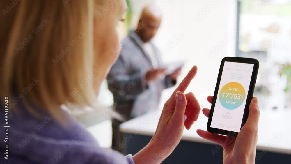 Close up of mature woman using app on mobile phone to adjust digital ...