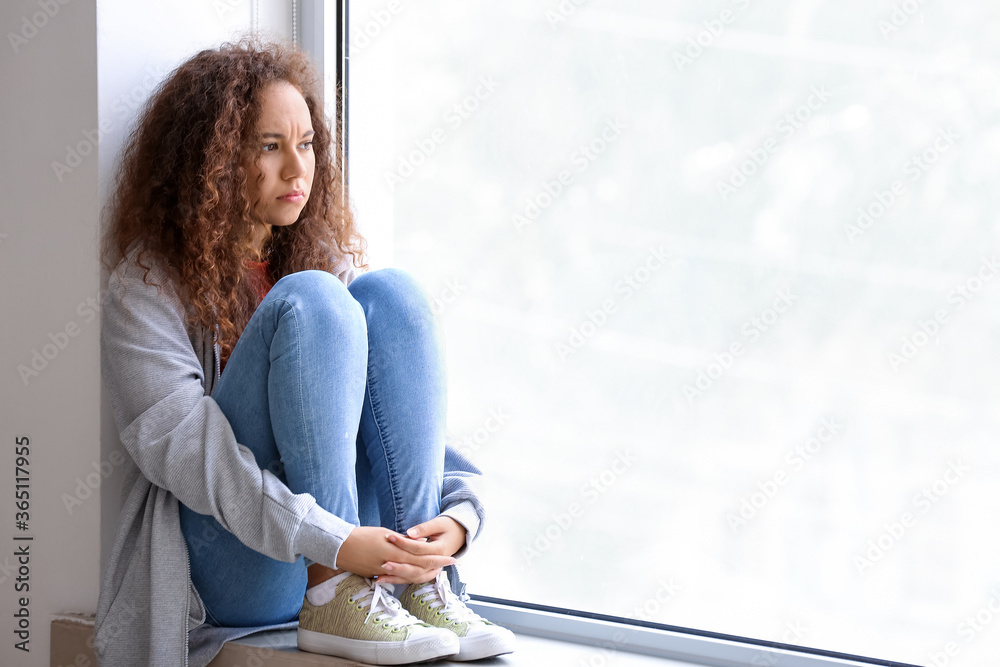 Sad African-American woman sitting on window sill. Stop racism Stock ...