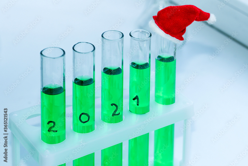 five vials of green solution in a chemical lab. on the end tube is a ...