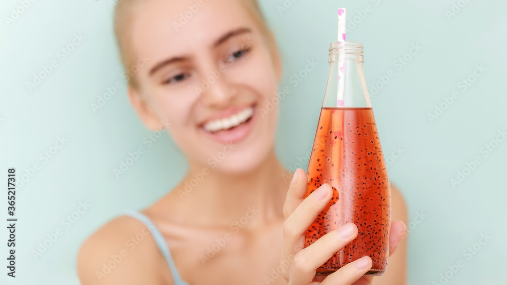 Foto de Girl drinks a drink from a glass bottle and shows emotions ...