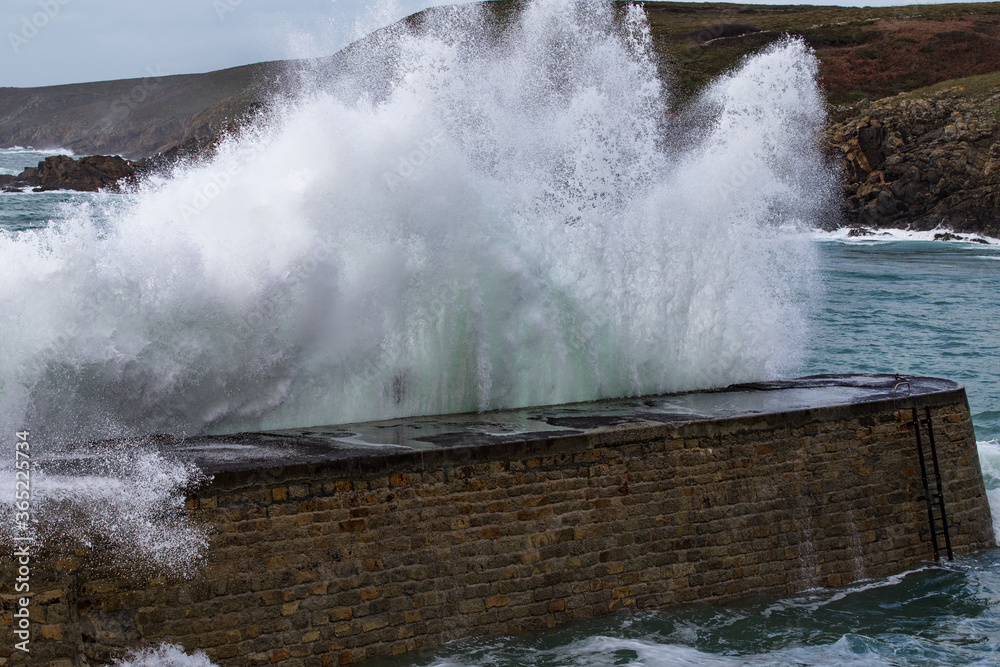 vague énorme se brisant sur la digue du port pendant la tempête Stock ...