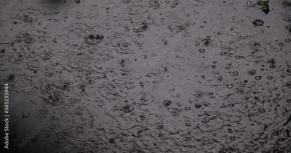 A strong storm outside. Top view of a shower with hail. Raindrops make ...