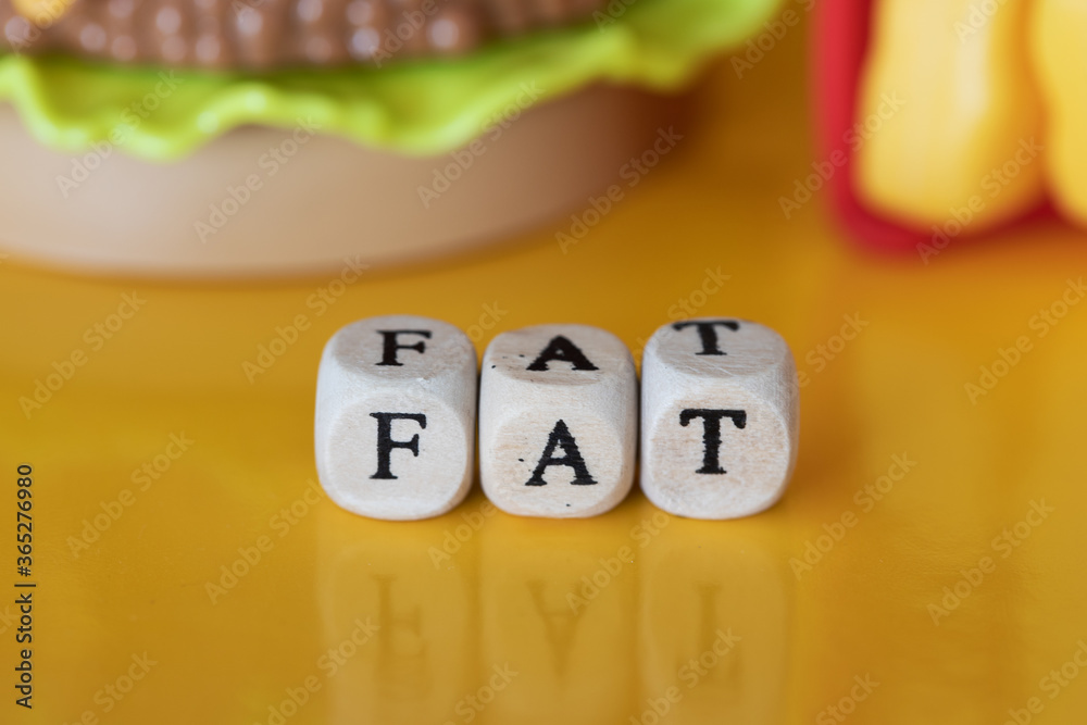 FAT letters on yellow background. hamburger and fries on background ...