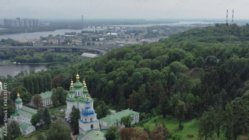 Quadrocopter flight over Vydubychi monastery with copper green roof ...
