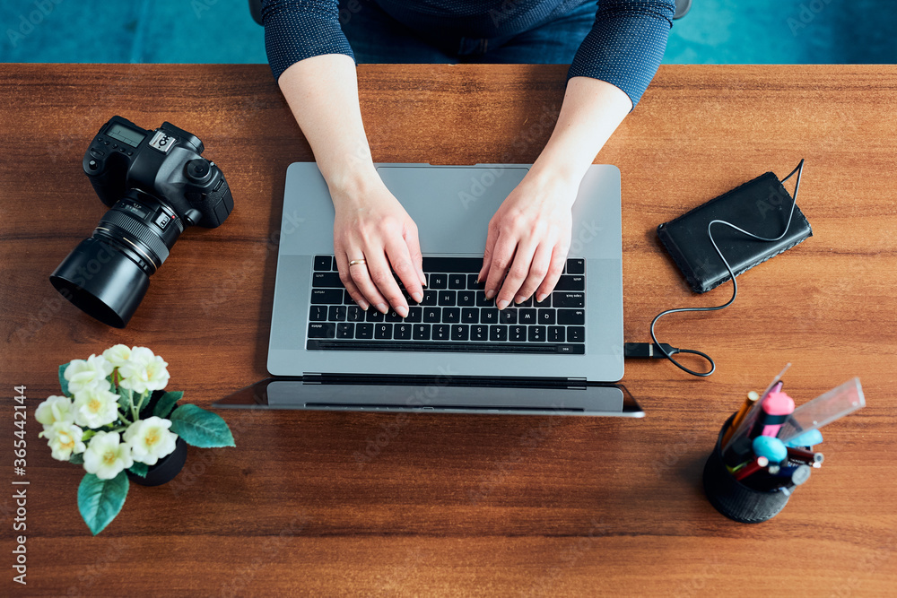 Female photographer working on photos on laptop and camera. Woman ...