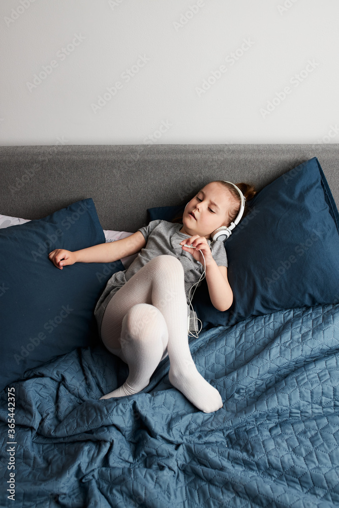 Little girl singing holding headphones cord imitating herself a real ...