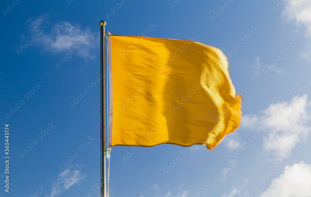 Yellow warning flag on a beach lifeguard station Stock Photo | Adobe Stock
