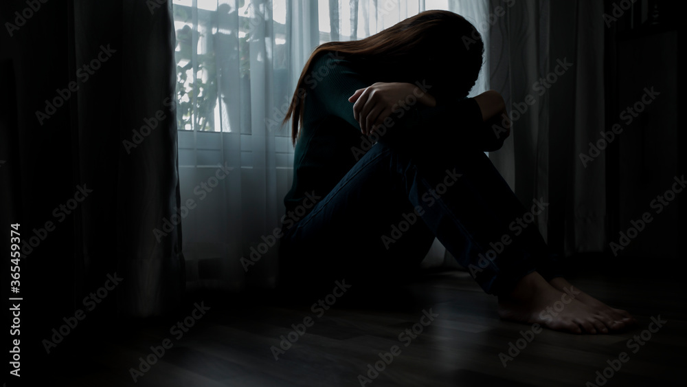 Sad young woman sitting on the bed in the bedroom, People with ...