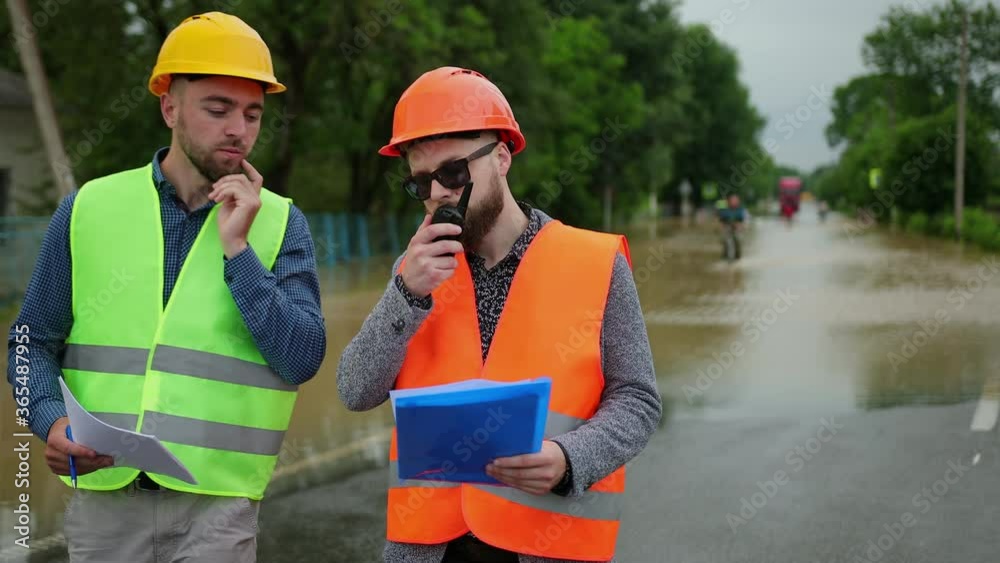 Two male engineers solve flood problem. Devastation wrought after ...