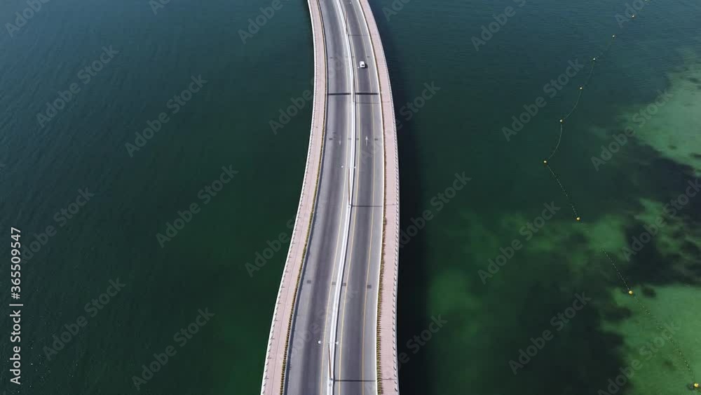Aerial landscap view of a curved bridge above water with cars passing ...