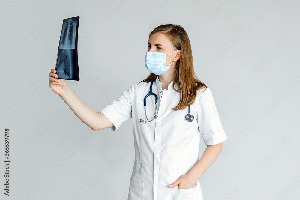 A female doctor examines an X-ray of a patient s lung infected with ...