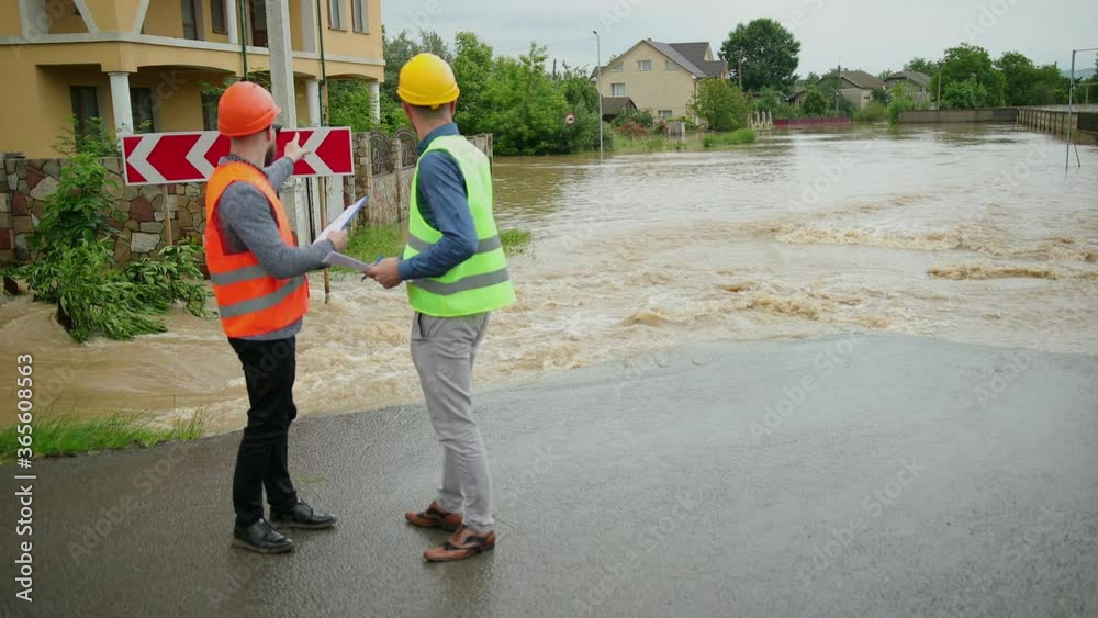 Two male engineers solve flood problem. Devastation wrought after ...