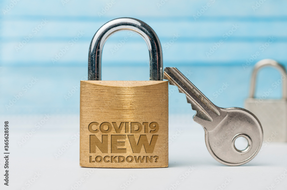 New lockdown due to covid-19 concept, a lock and a key with a surgical ...