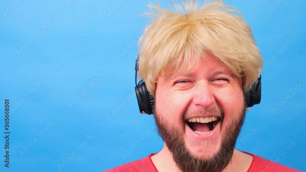 laughing freaky fat man in a wig and a pink T-shirt in his hands ...