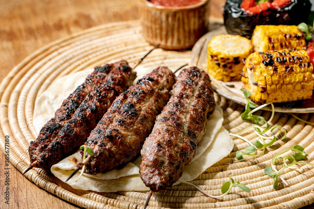 Eastern fast food. Grilled spicy beef lyulya kebab on sticks on flat ...