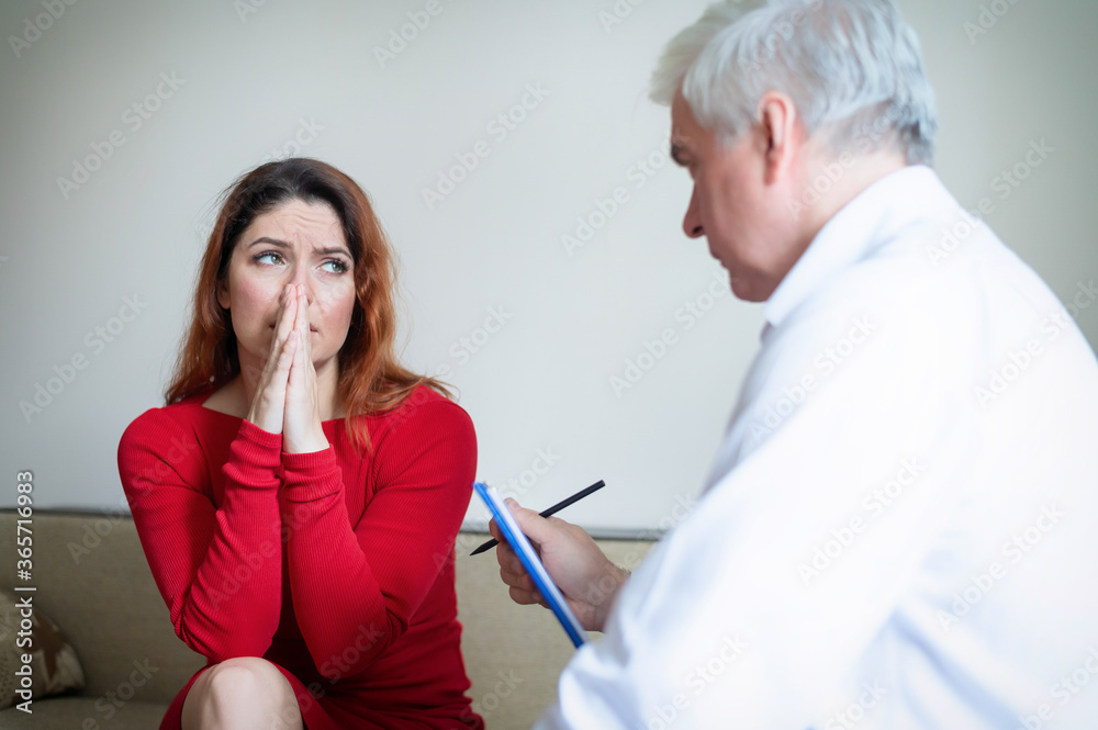 Caucasian woman cries and holds hands on her face at the session of a ...