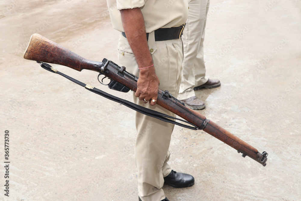 indian police officer holding the big gun Stock Photo | Adobe Stock
